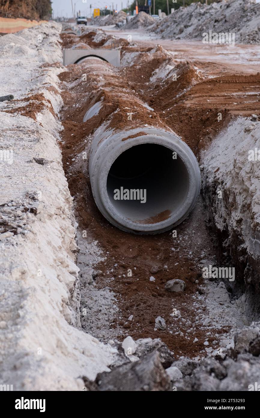 Laying sewer Concrete drainage pipe between large residential areas ...