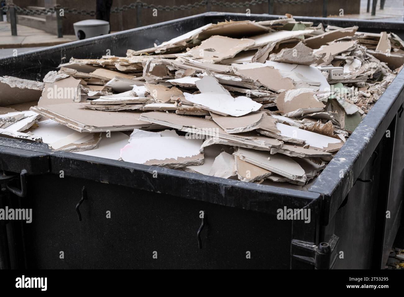 an overloaded dumpster waste container, with construction waste and ...