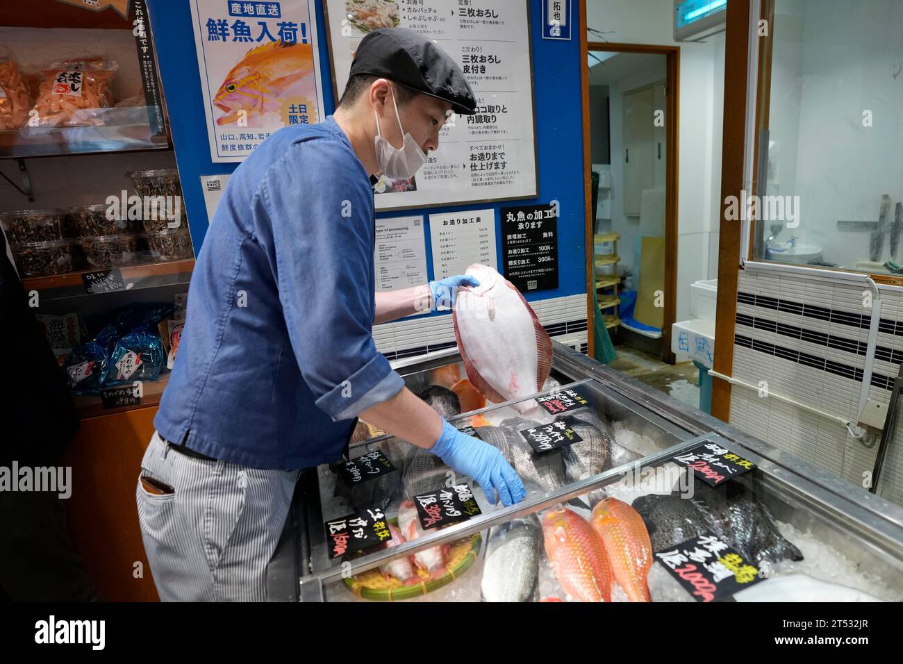 A staff member holds a flounder from Fukushima at Sakana Bacca, a ...