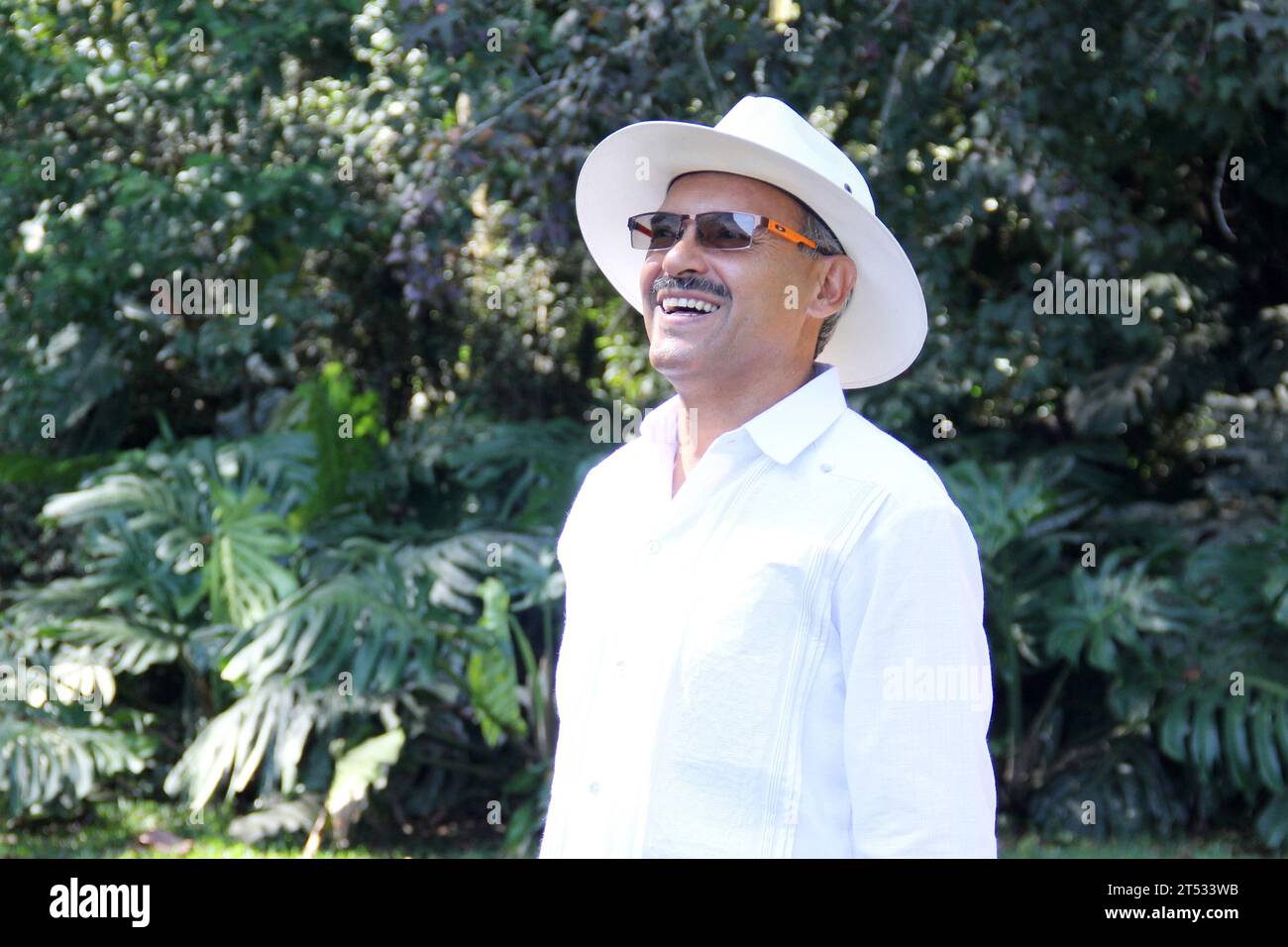 Elderly dark-skinned Latino man in his 60s appears relaxed in his ...