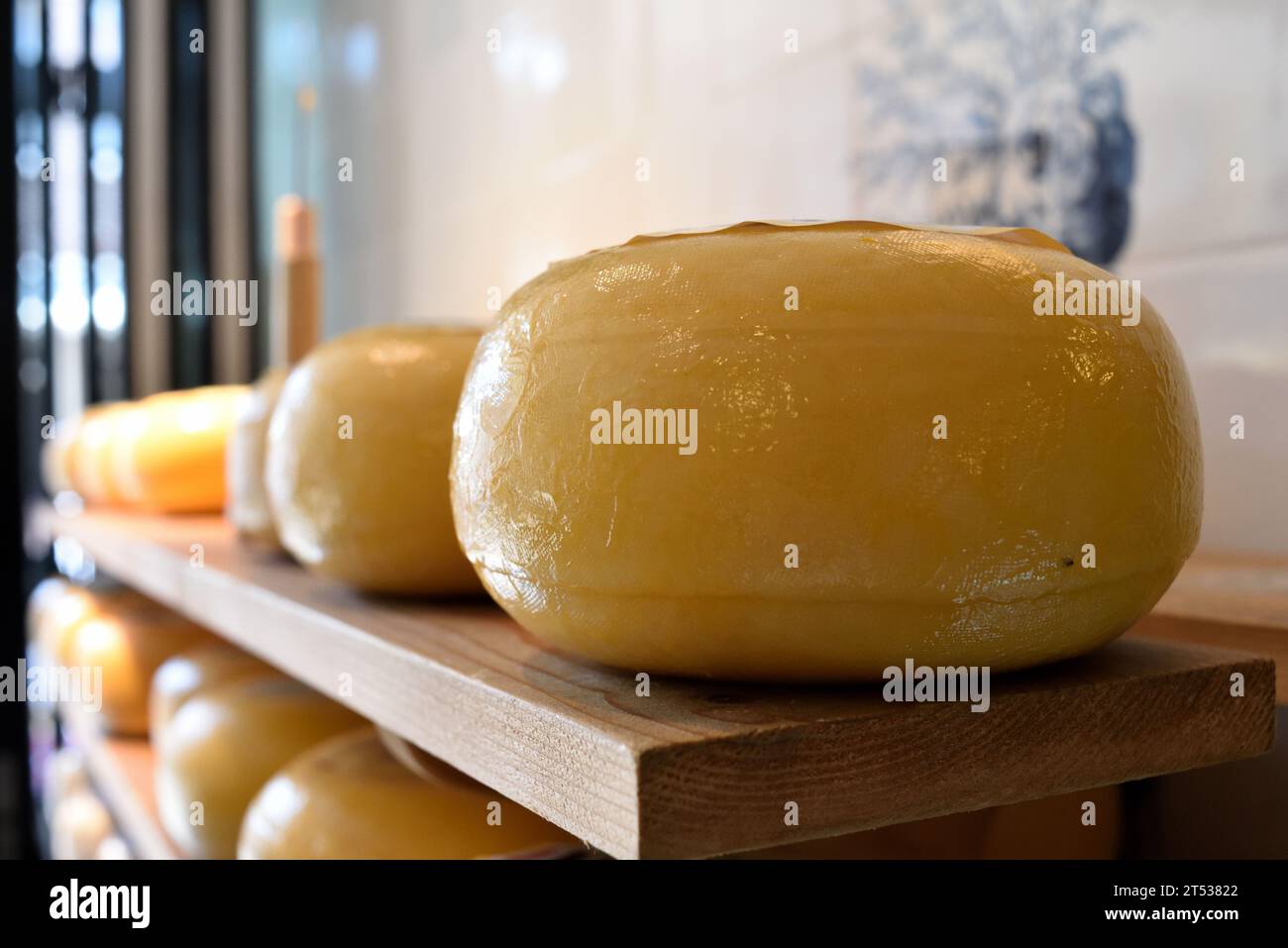 A wooden shelf with an array of different types of cheese on top Stock ...