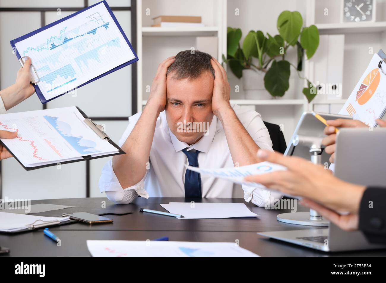 Mature businessman suffering from noisy colleagues in office Stock ...