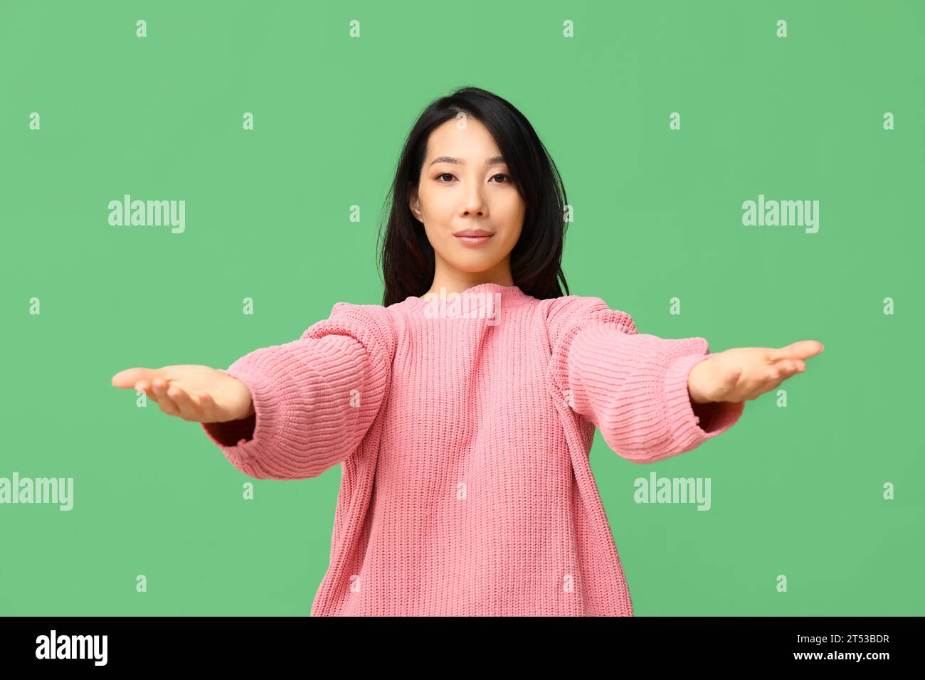 Young Asian woman opening arms for hug on green background Stock Photo ...
