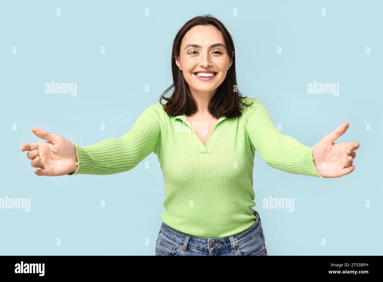 Young woman opening arms for hug on blue background Stock Photo - Alamy