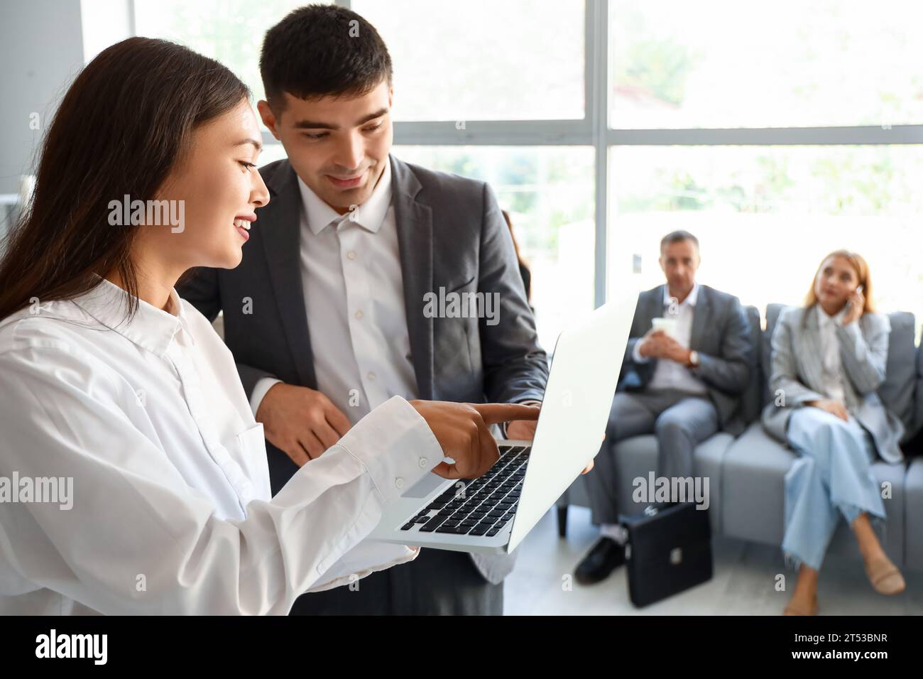 Business people with laptop in office hall Stock Photo - Alamy