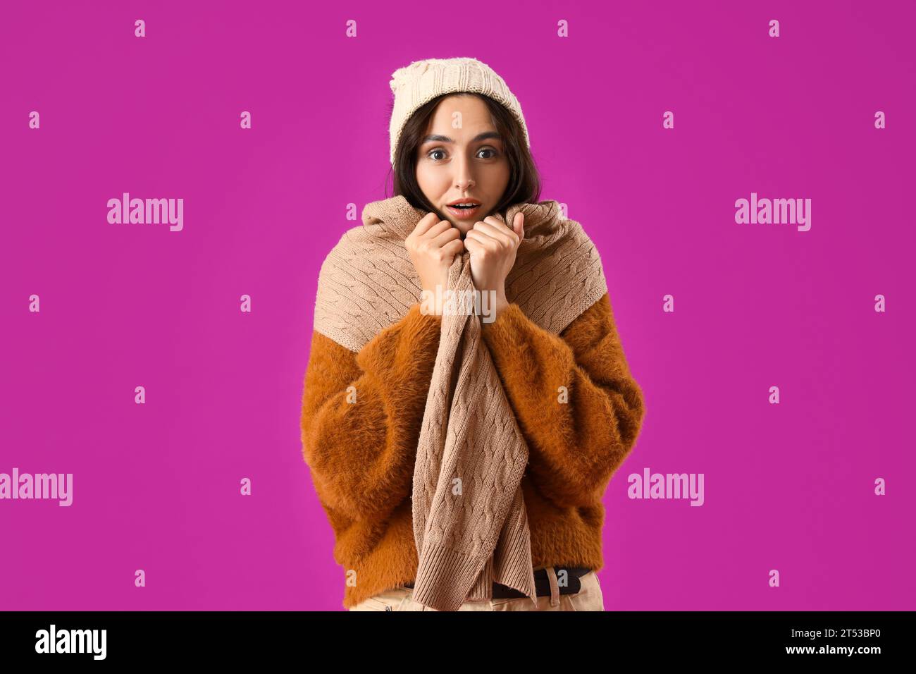 Frozen young woman in winter clothes on purple background Stock Photo ...