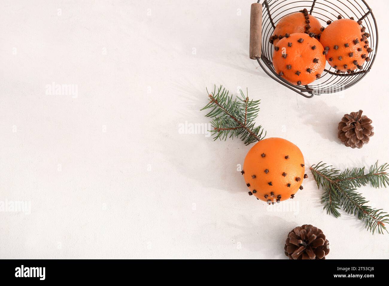 Basket with pomander balls and Christmas tree branches on white ...