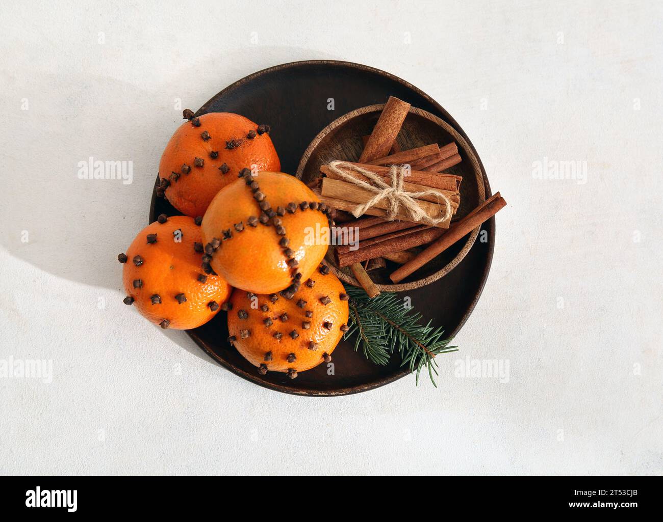 Wooden plate with pomander balls and cinnamon on white background Stock ...