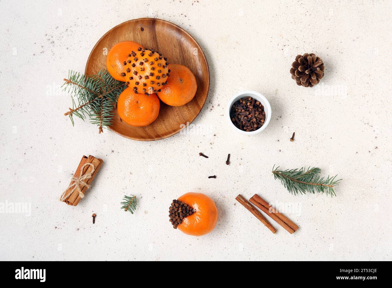 Wooden plate with pomander balls and Christmas tree branches on white ...