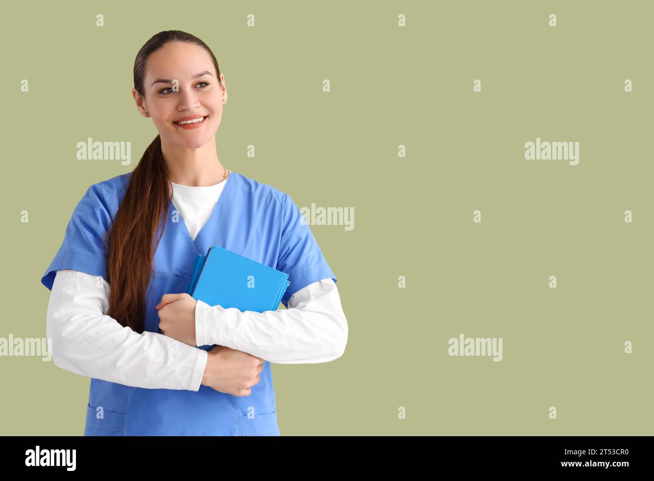 Female medical intern with books on green background Stock Photo - Alamy