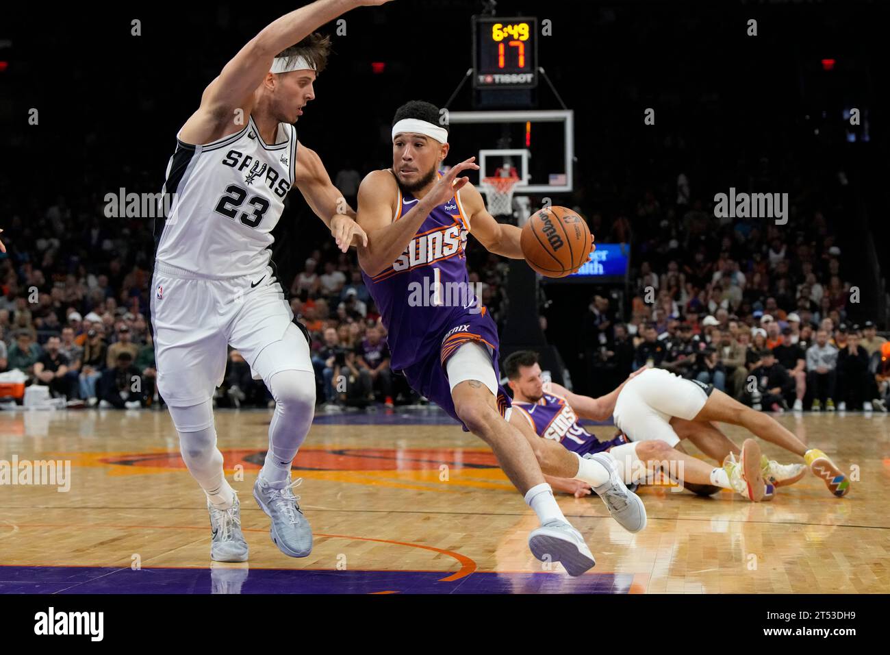 Phoenix Suns guard Devin Booker (1) drives past San Antonio Spurs forward Zach Collins (23 ...