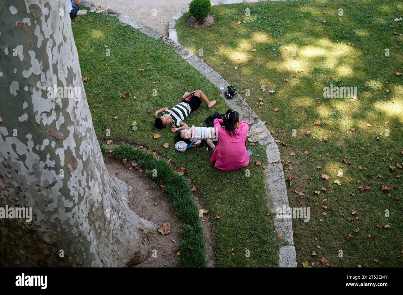 mom and her two kids unwind by removing their shoes, feeling the soft ...