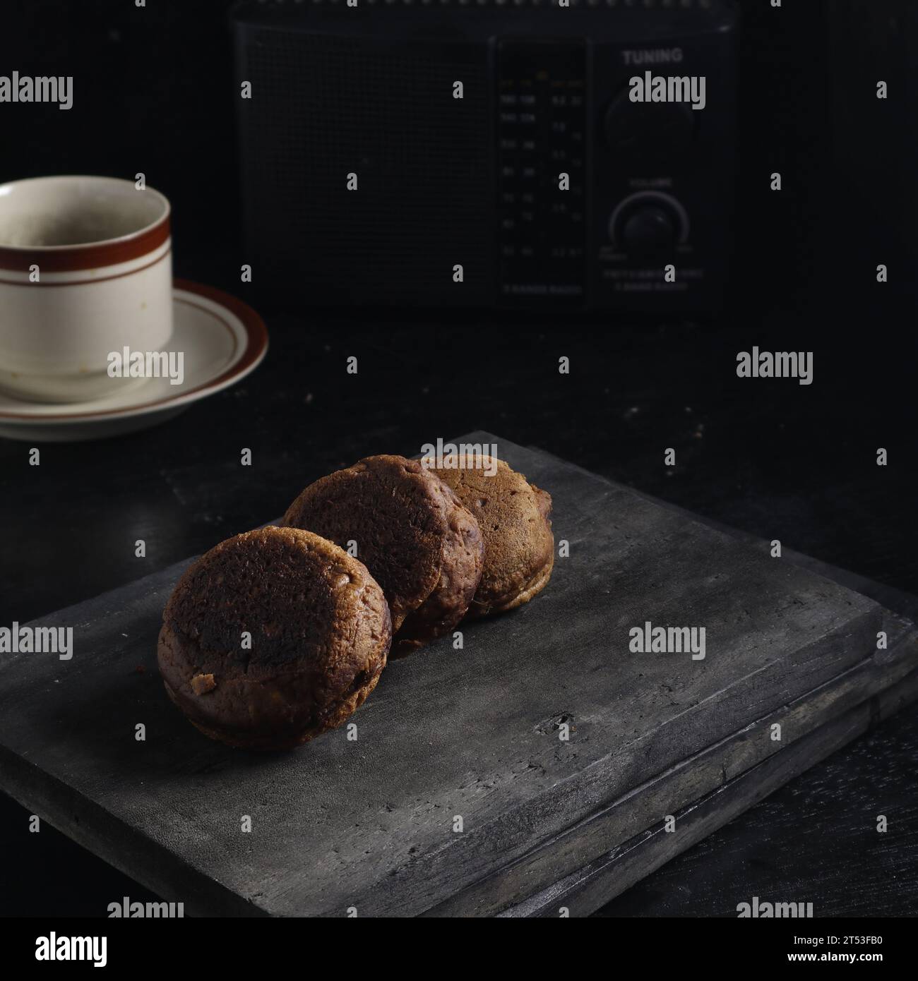 Apang bale cake or Apang bakar, and a cup of tea isolated on black ...