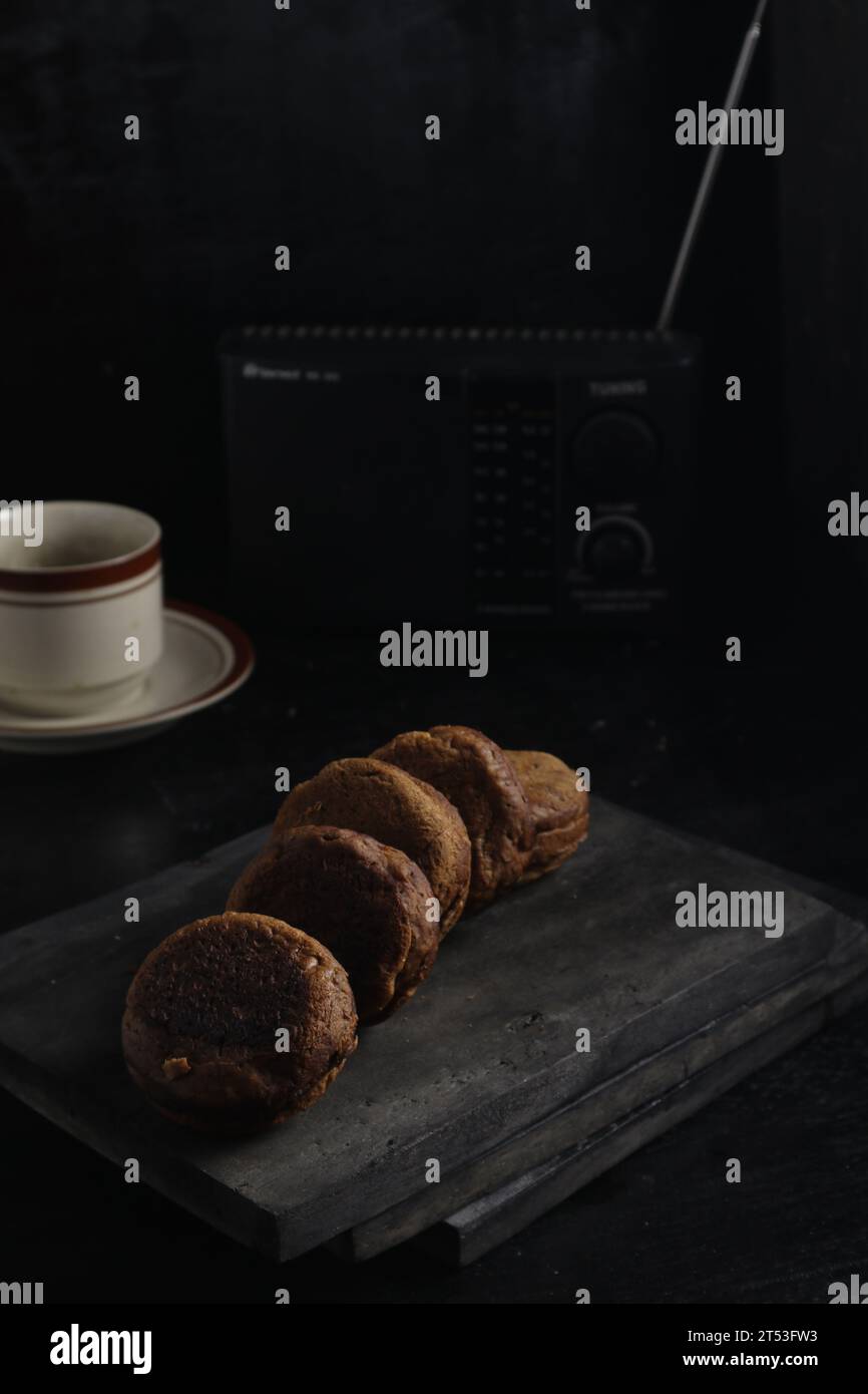 Apang bale cake or Apang bakar, and a cup of tea isolated on black ...