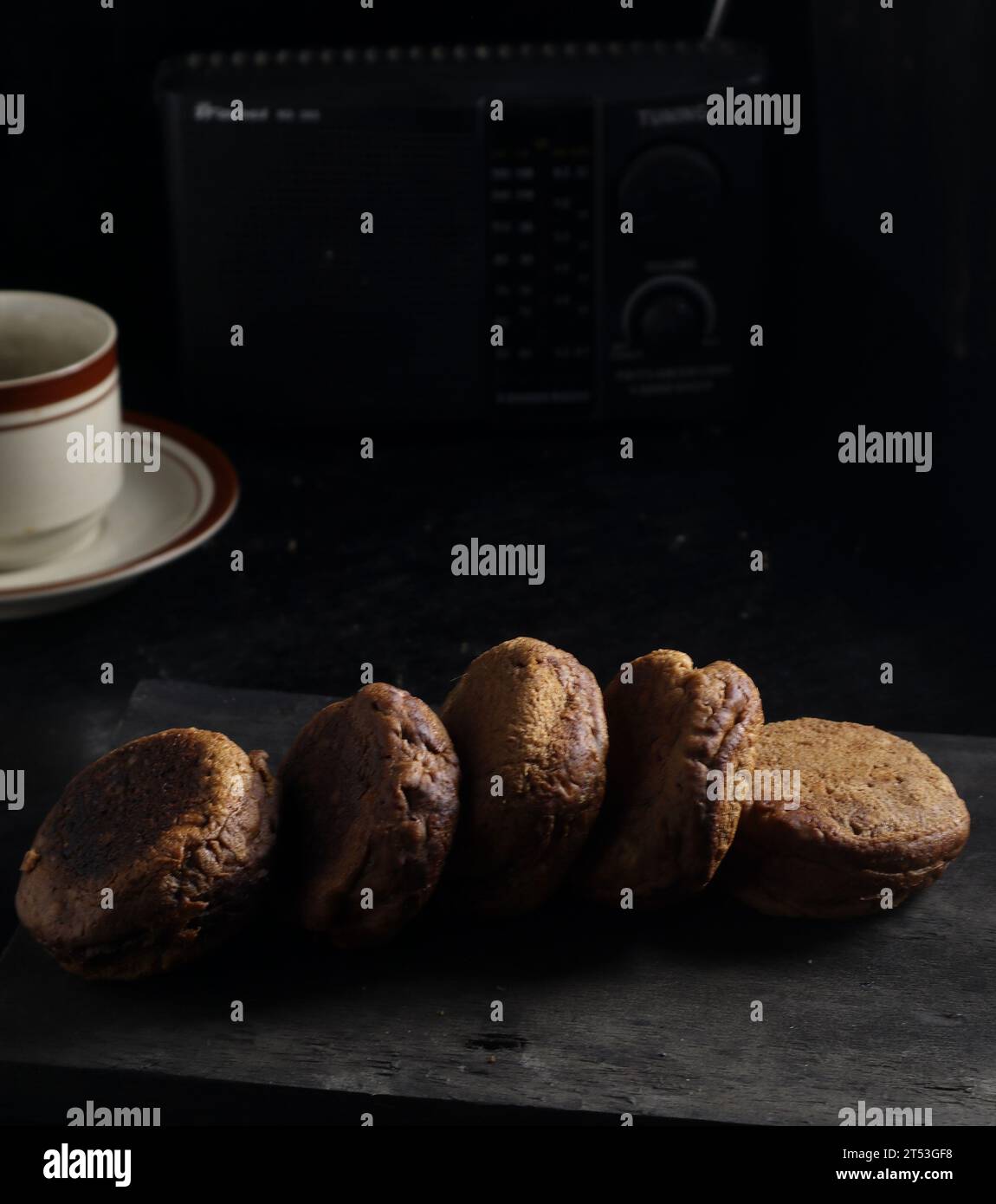 Apang bale cake or Apang bakar, and a cup of tea isolated on black ...