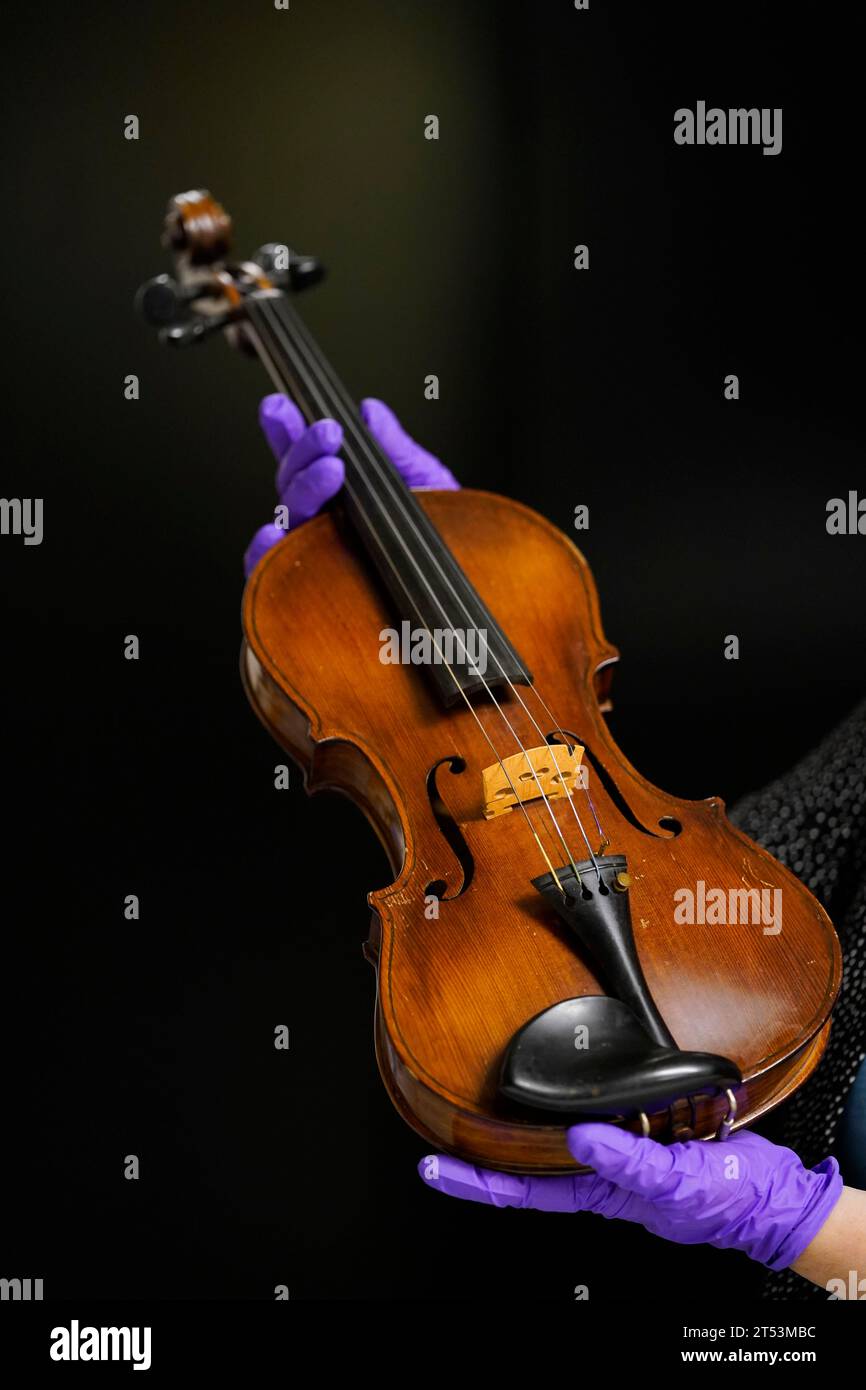 Kim Guise, curator for the National World War II Museum, shows a violin ...