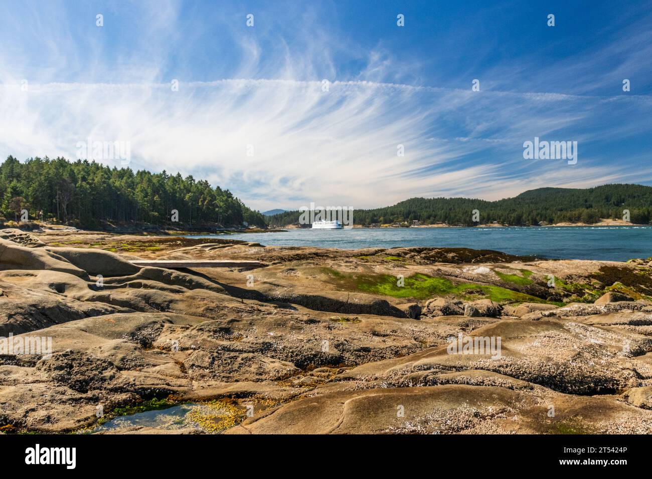 A ferry passes through Active Pass at Georgina Point on Mayne Island ...
