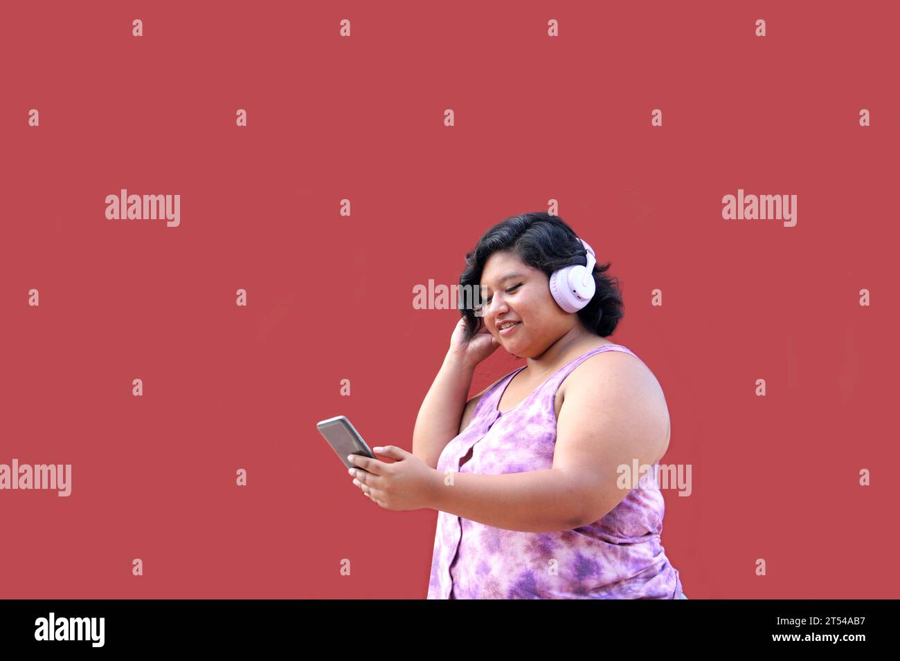Young 20-year-old brunette and fat woman uses headphones connected to ...