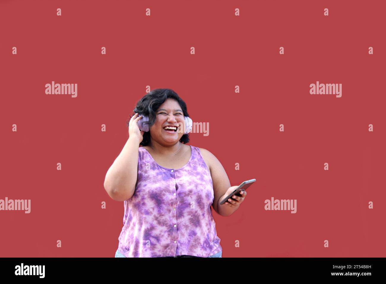 Young 20-year-old brunette and fat woman uses headphones connected to ...