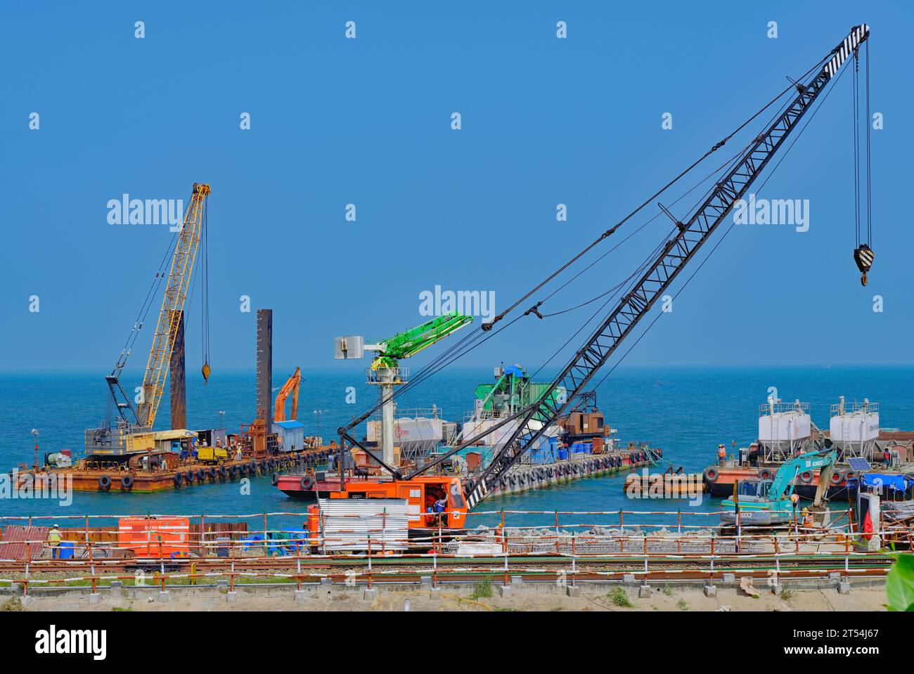 Floating cranes at work to build a bridge on the sea Stock Photo - Alamy