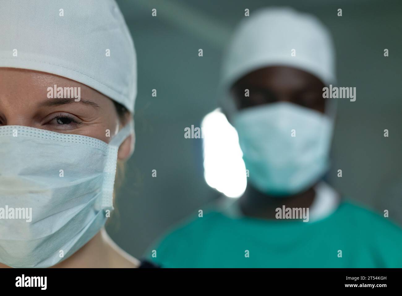Portrait of diverse male and female surgeons wearing surgical gowns in ...