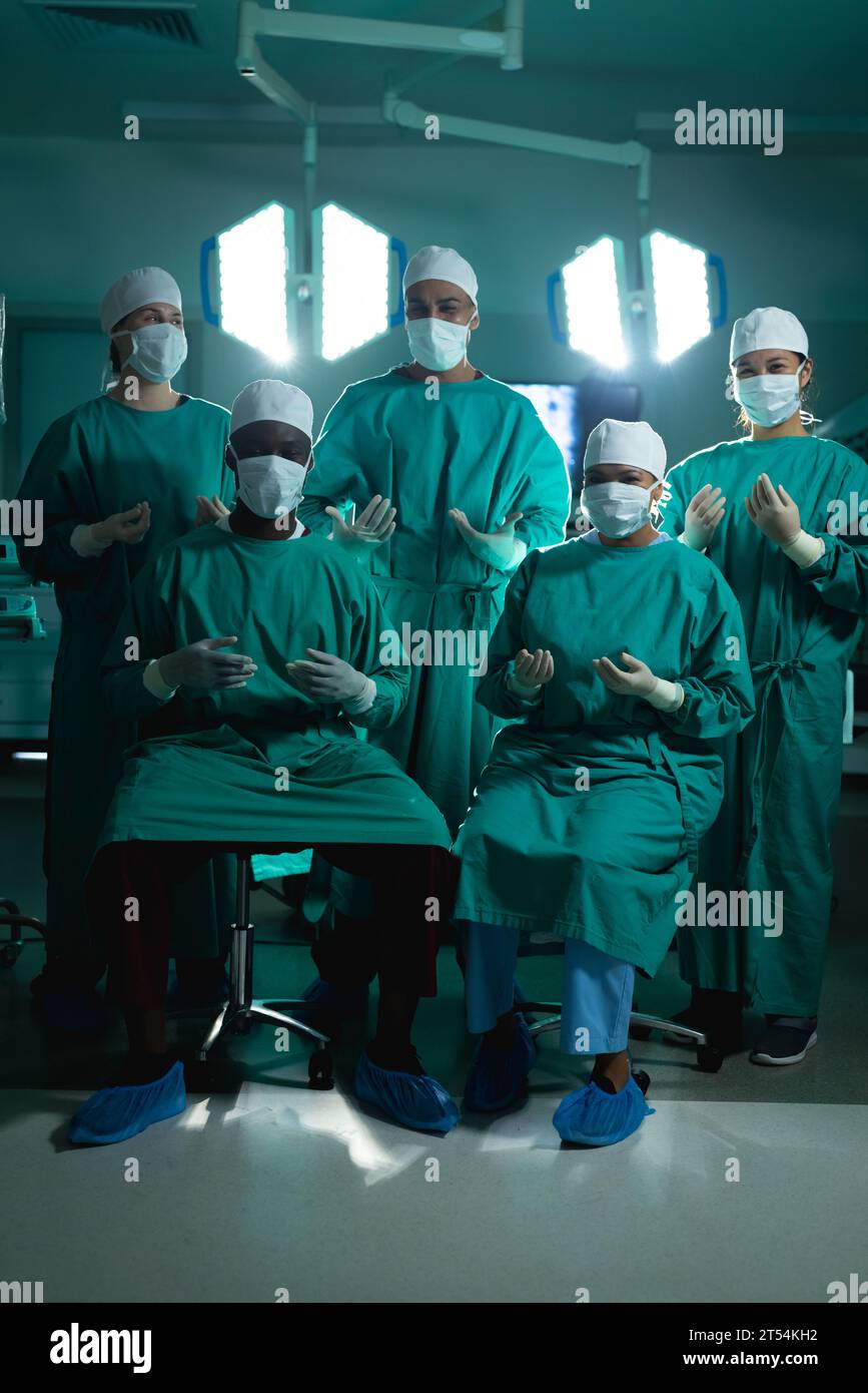 Portrait of diverse male and female surgeons wearing surgical gowns in ...