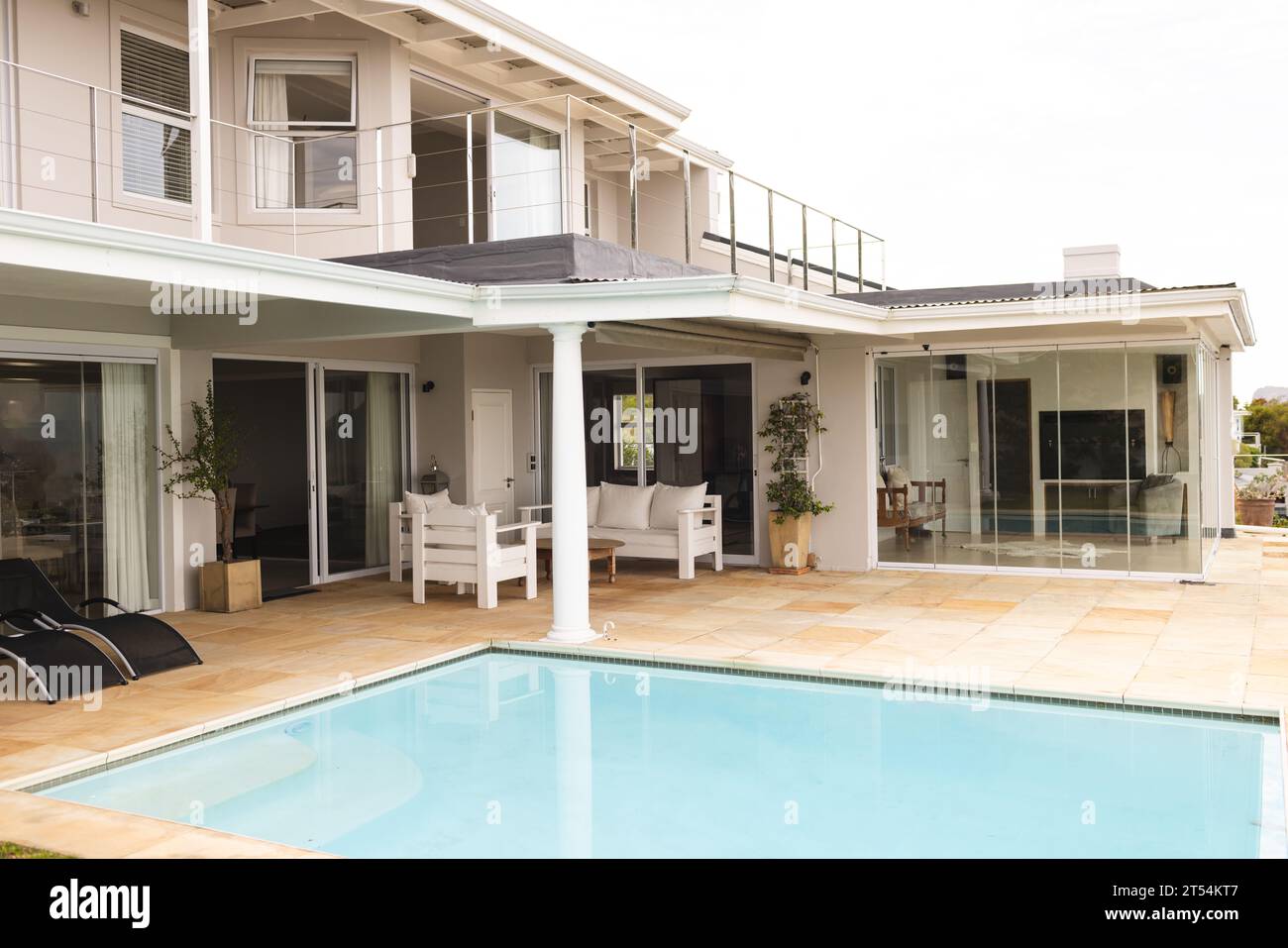 Big white house with white furniture and big terrace with sunbeds and ...