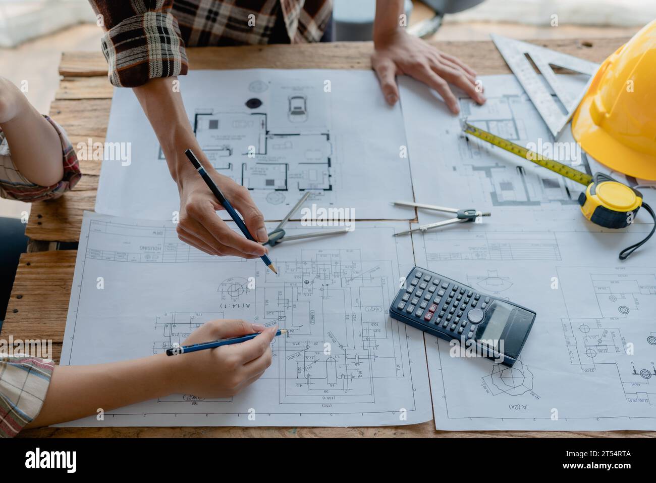 multi ethnic engineer brainstorming and measuring for cost estimating ...