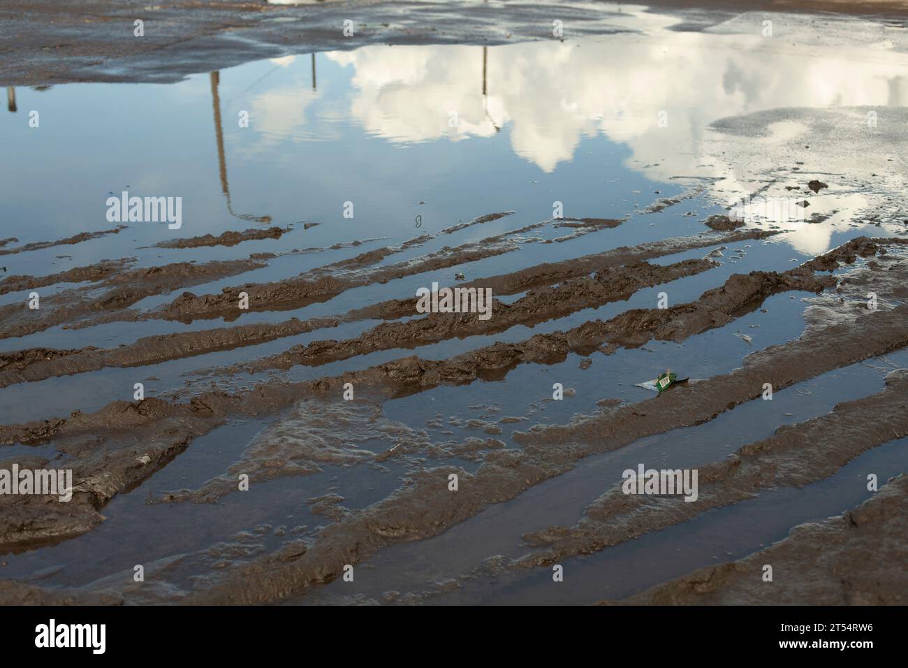 Big puddle. The dirt on the road. Water outside. Clouds are reflected ...