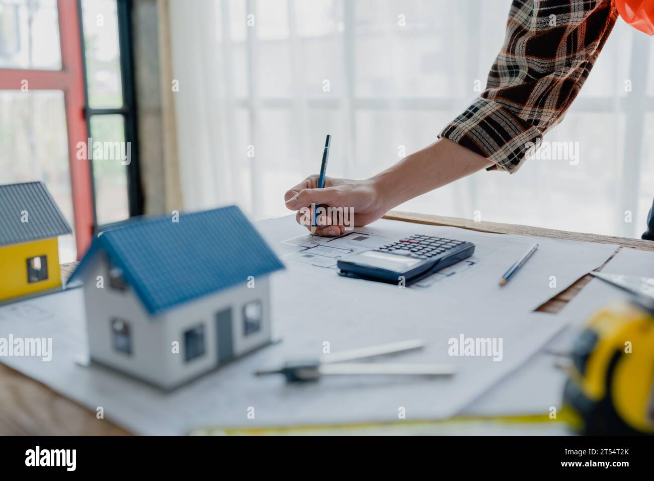 engineer brainstorming and measuring for cost estimating on blueprint ...