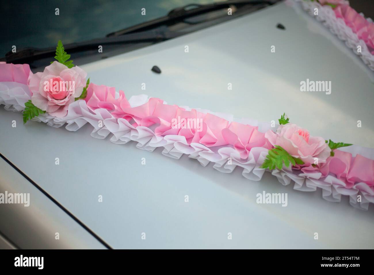 Tape on the car. Wedding decoration on transport. Pink ribbon on the ...