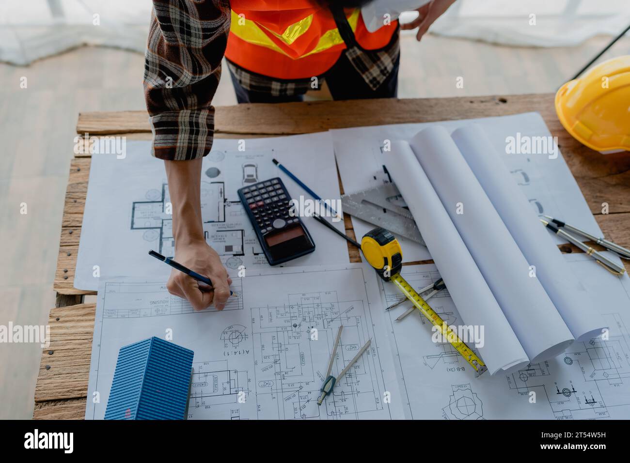 engineer brainstorming and measuring for cost estimating on blueprint ...