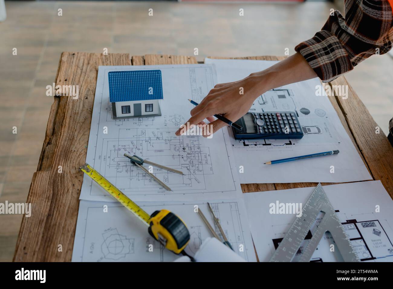 engineer brainstorming and measuring for cost estimating on blueprint ...