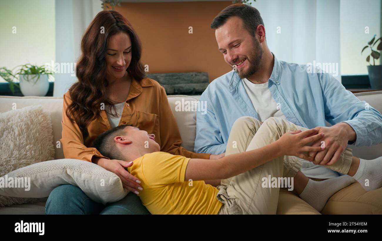 Happy caucasian family dad mom with cute kid son tickling having fun ...