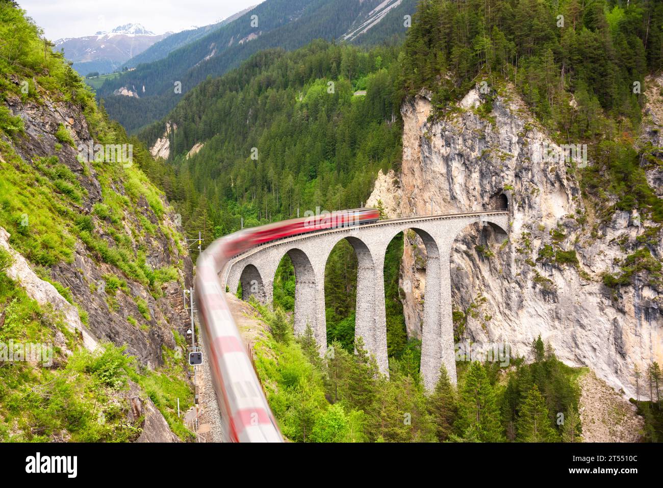 Swiss red train on viaduct in mountain for scenic ride Stock Photo - Alamy