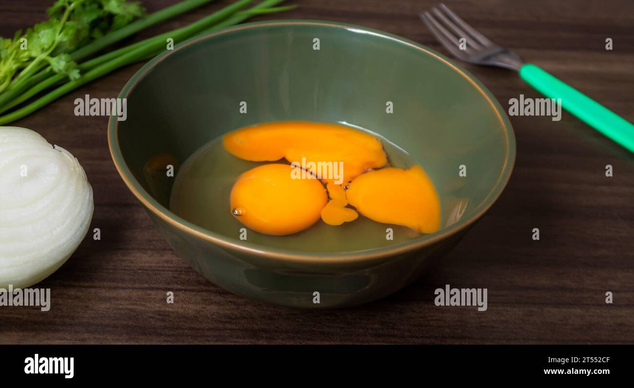 Fresh natural eggs in a bowl with spring onions and coriander to ...