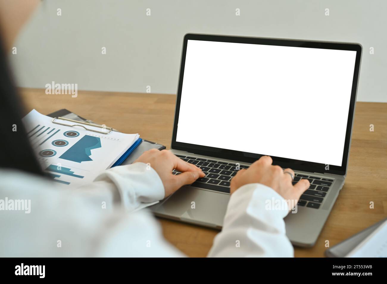 View over shoulder female employee using laptop on office desk. White ...