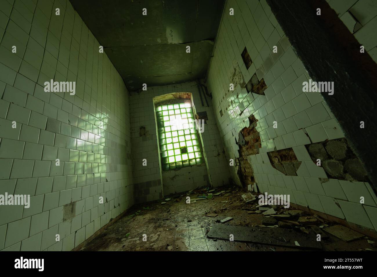 From above view of narrow room with shabby walls broken ceramic tiles ...