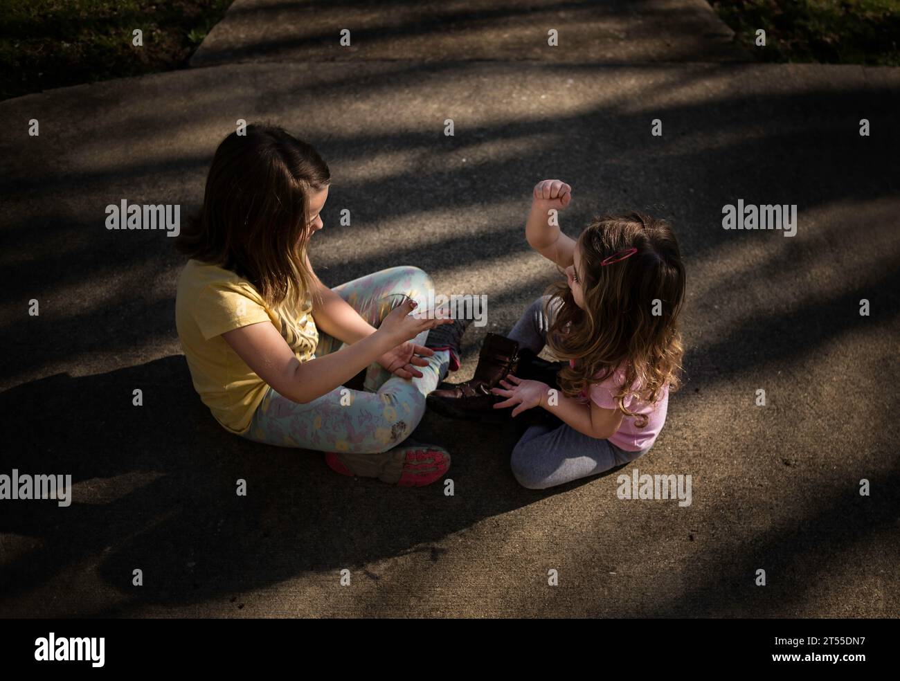 Sisters playing rock, paper scissors outside Stock Photo - Alamy