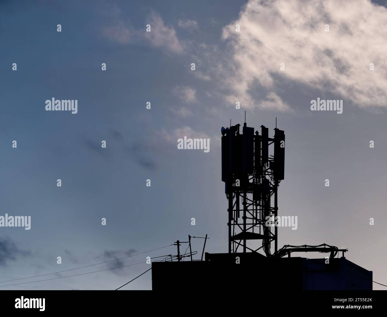 Silhouette of telecommunication tower with microwave panel antennas ...