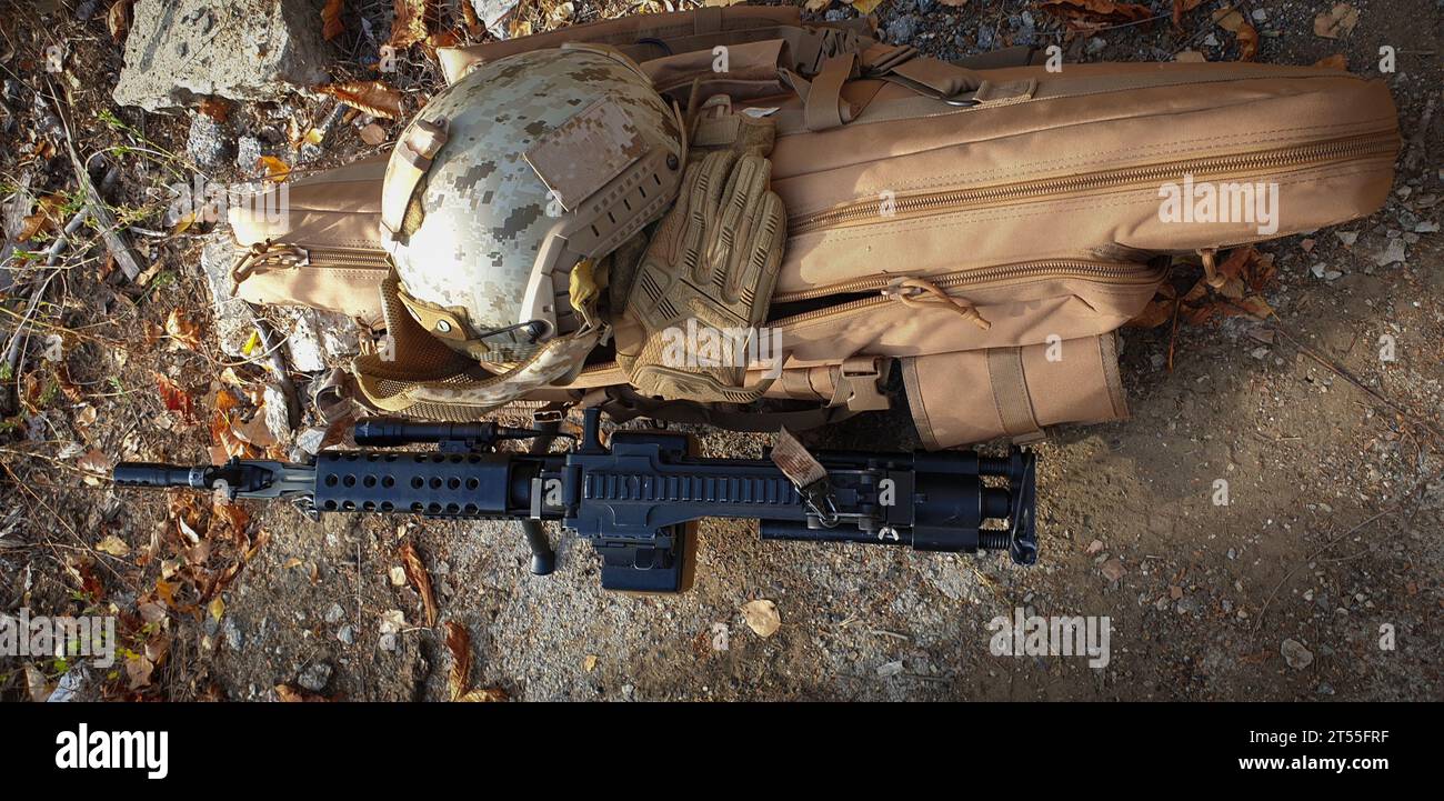 airsoft machine gun black next to a beige bag and helmet Stock Photo ...