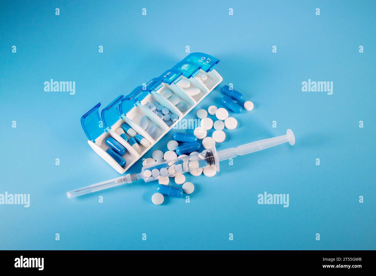 Blue-white pills and capsules in weekly pill organizer Stock Photo - Alamy