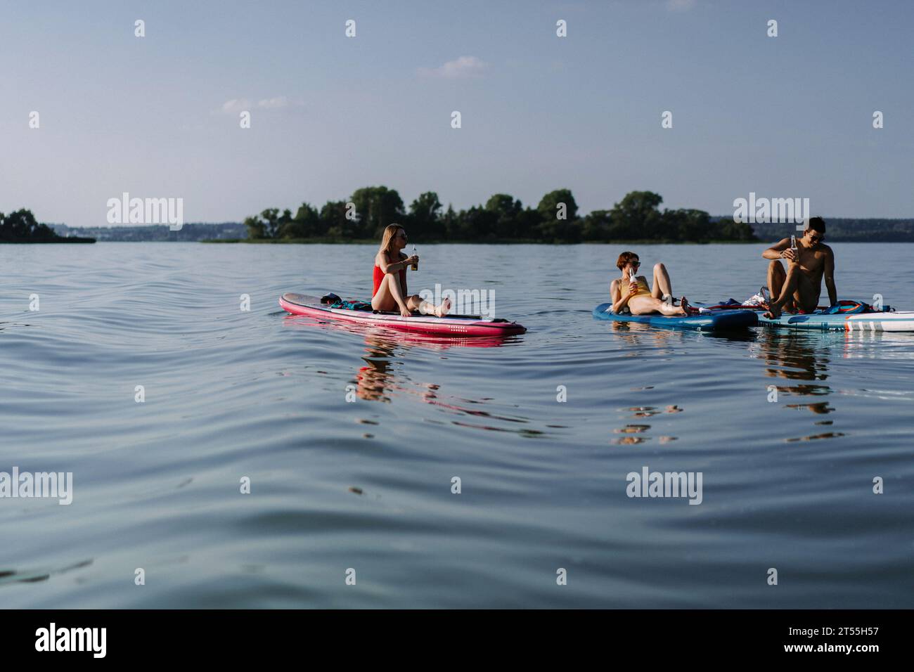 Friends drinking beer on a summer vacation on the lake, paddleboard ...