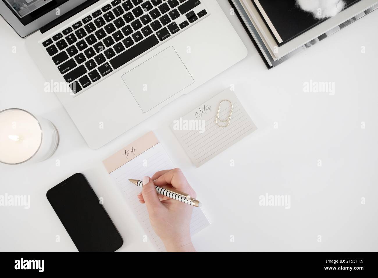 Writing a note on a desk with laptop computer Stock Photo - Alamy