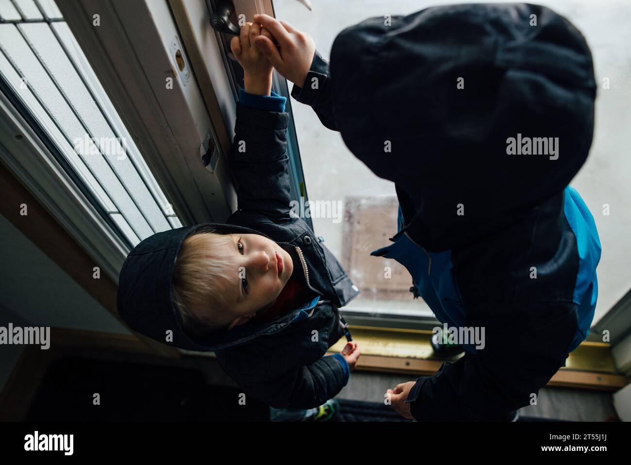 Overhead shot of little blonde boy reaching for door handle to Stock ...