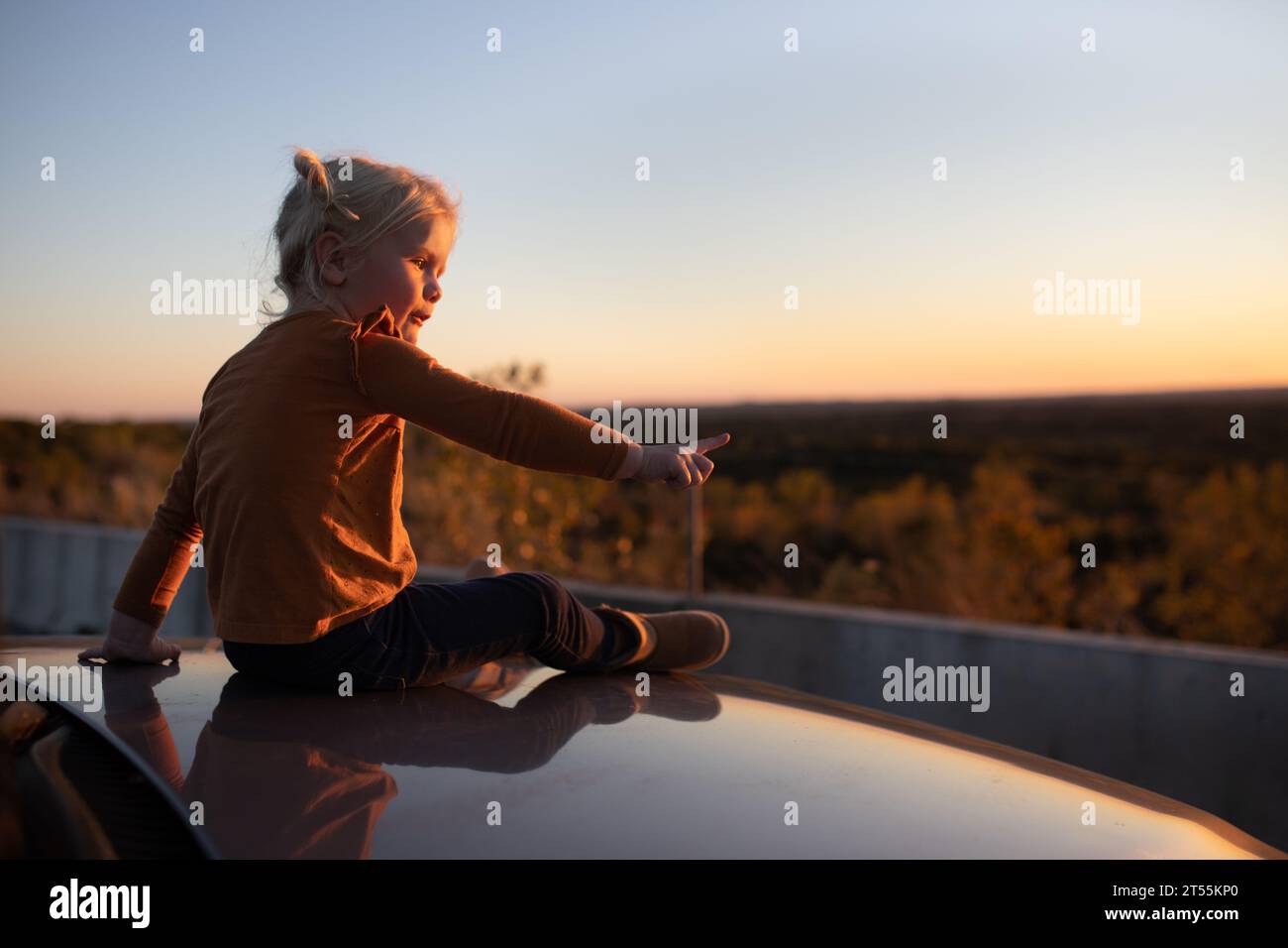 Child pointing into distance at scenic overlook during sunset Stock ...