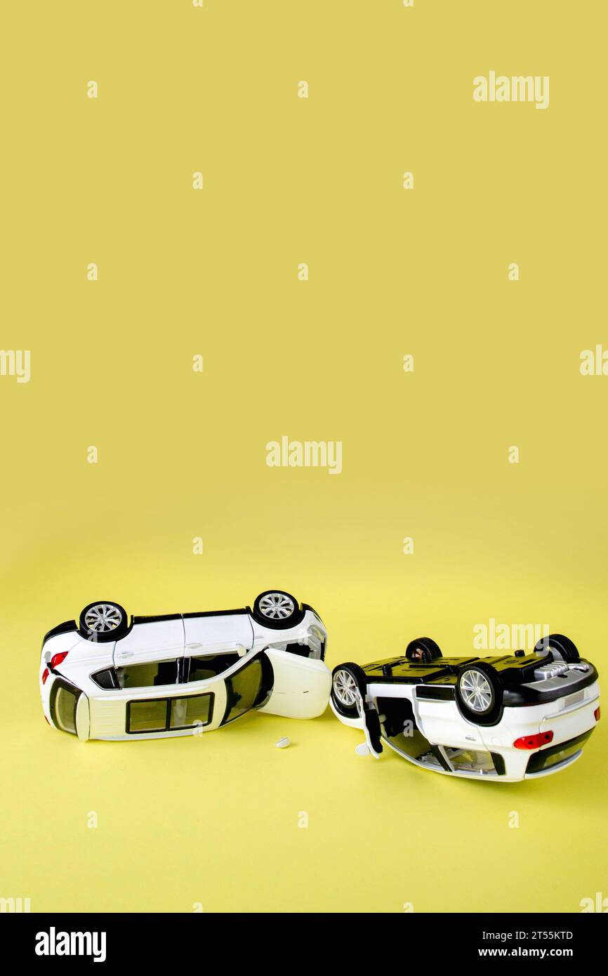 Two mini toy car crash on yellow background, incident, car traffic ...