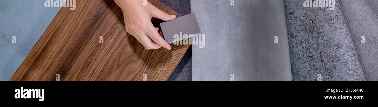 An interior designer's hand selects a palette of sample materials that ...