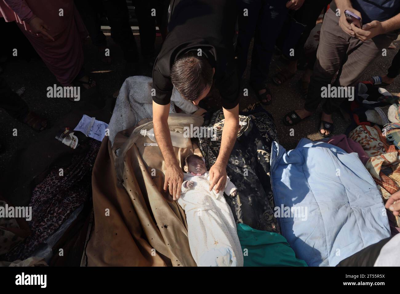 Palestinians mourns carrying a shrouded baby body to be buried after ...