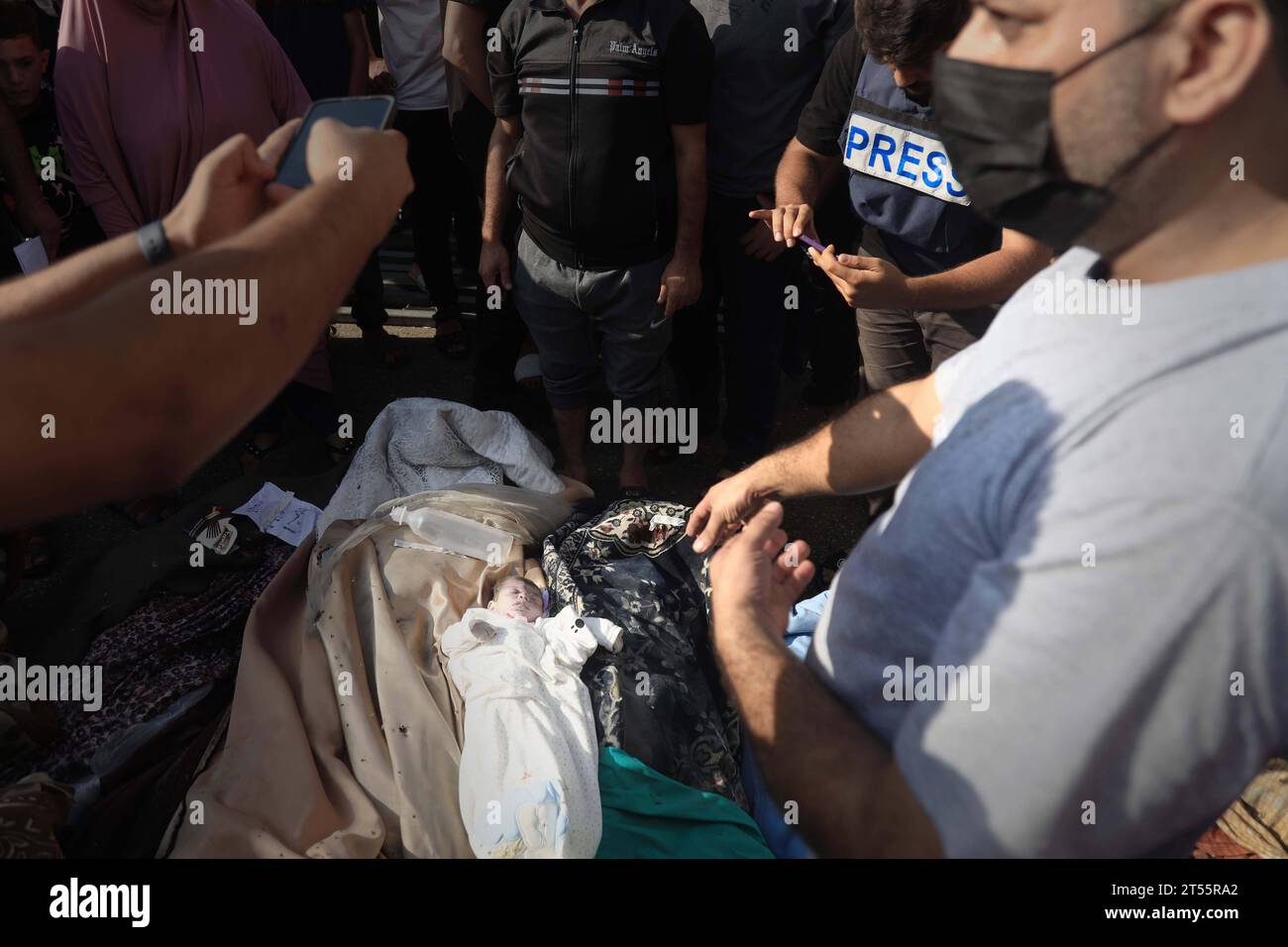 Palestinians mourns carrying a shrouded baby body to be buried after ...